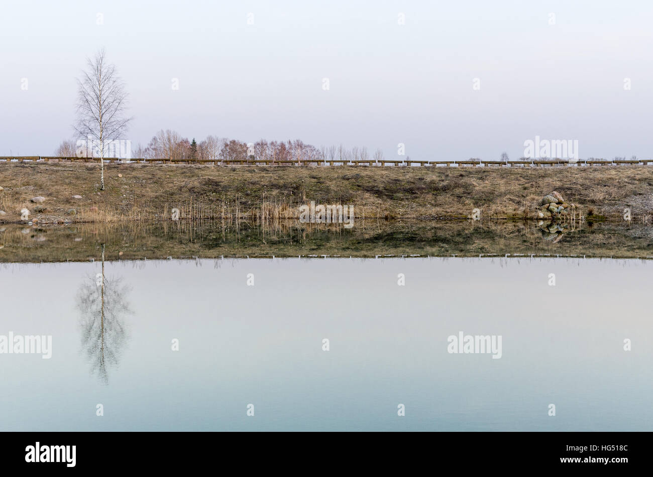 Coastal reflection in the water. Early spring evening Stock Photo - Alamy