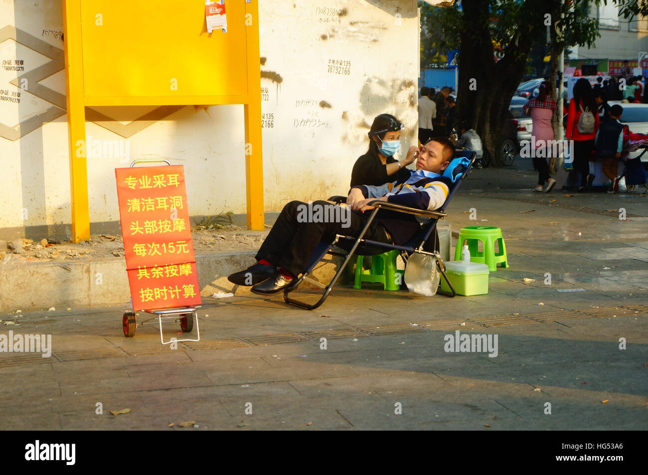 Chinese young women are cleaning ears for male customers in the streets ...