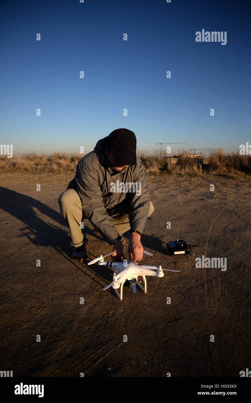 Young man flying a quadcopter DJI phantom drone outdoors Stock Photo ...