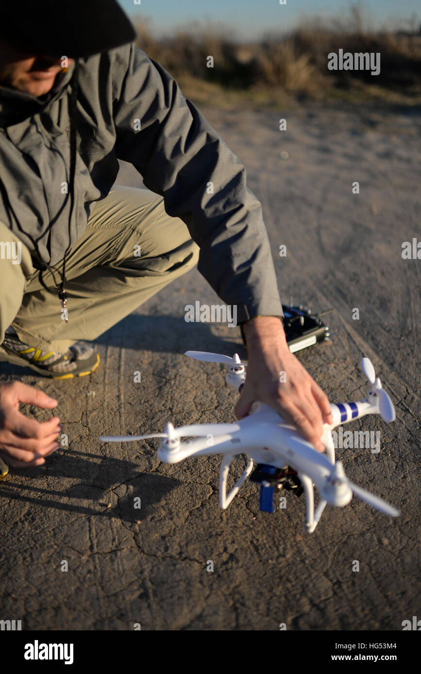 Young man flying a quadcopter DJI phantom drone outdoors Stock Photo ...