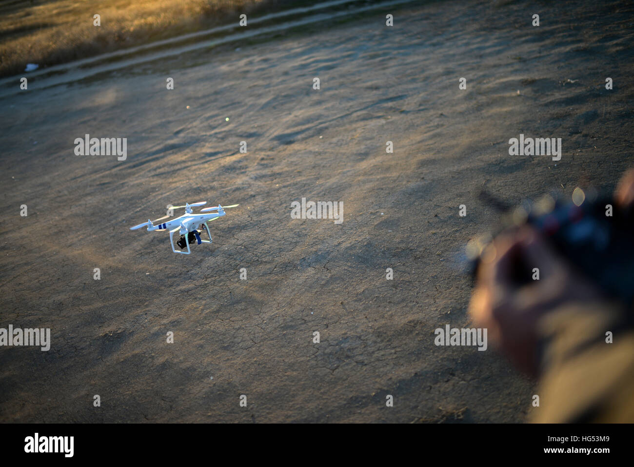 Young man flying a quadcopter DJI phantom drone outdoors Stock Photo ...