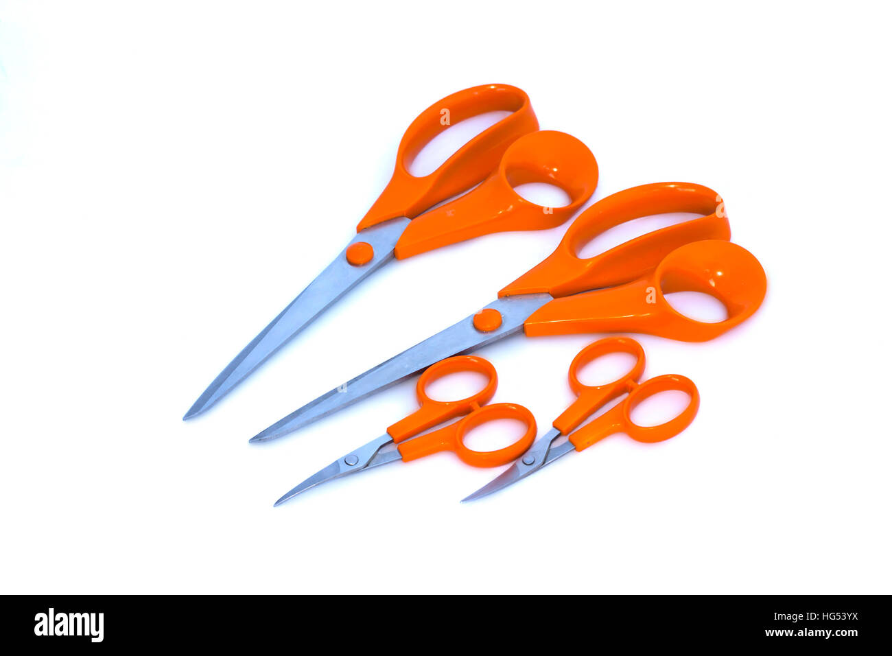 Four scissors with orange handles on a white background Stock Photo - Alamy