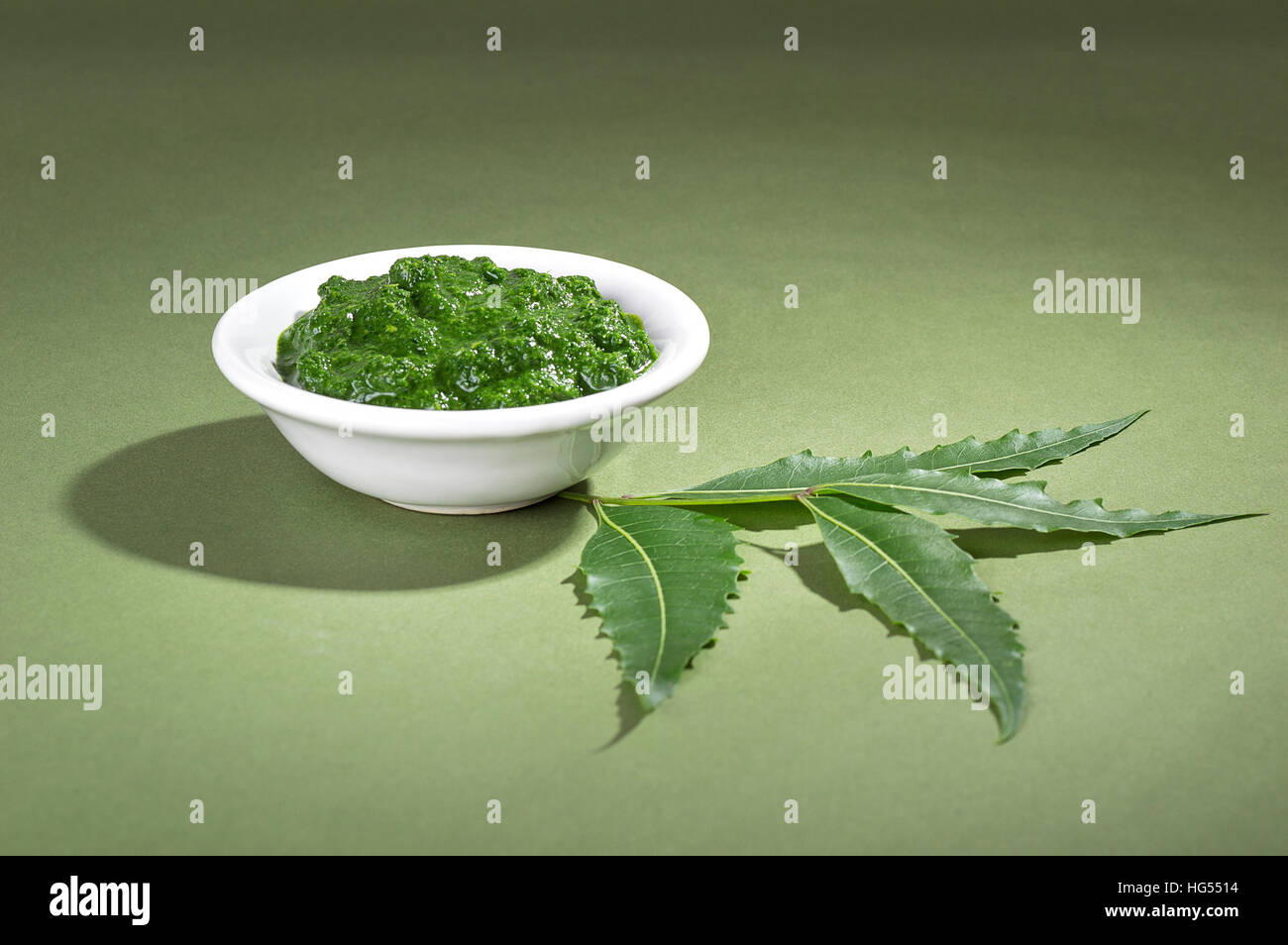 Medicinal Neem leaves with paste in bowl on green background Stock ...
