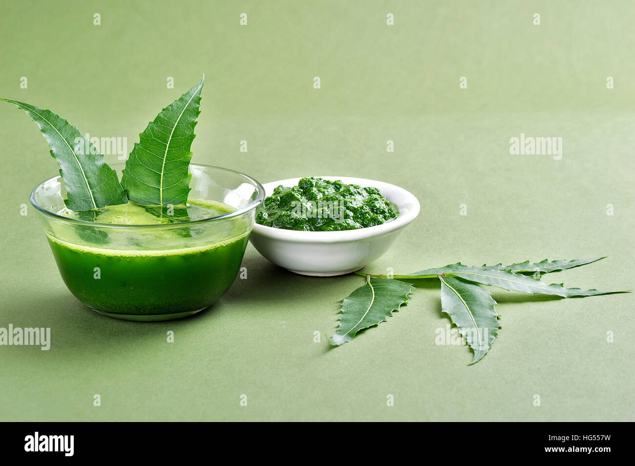 Medicinal Neem leaves paste and juice with leaves on green background ...