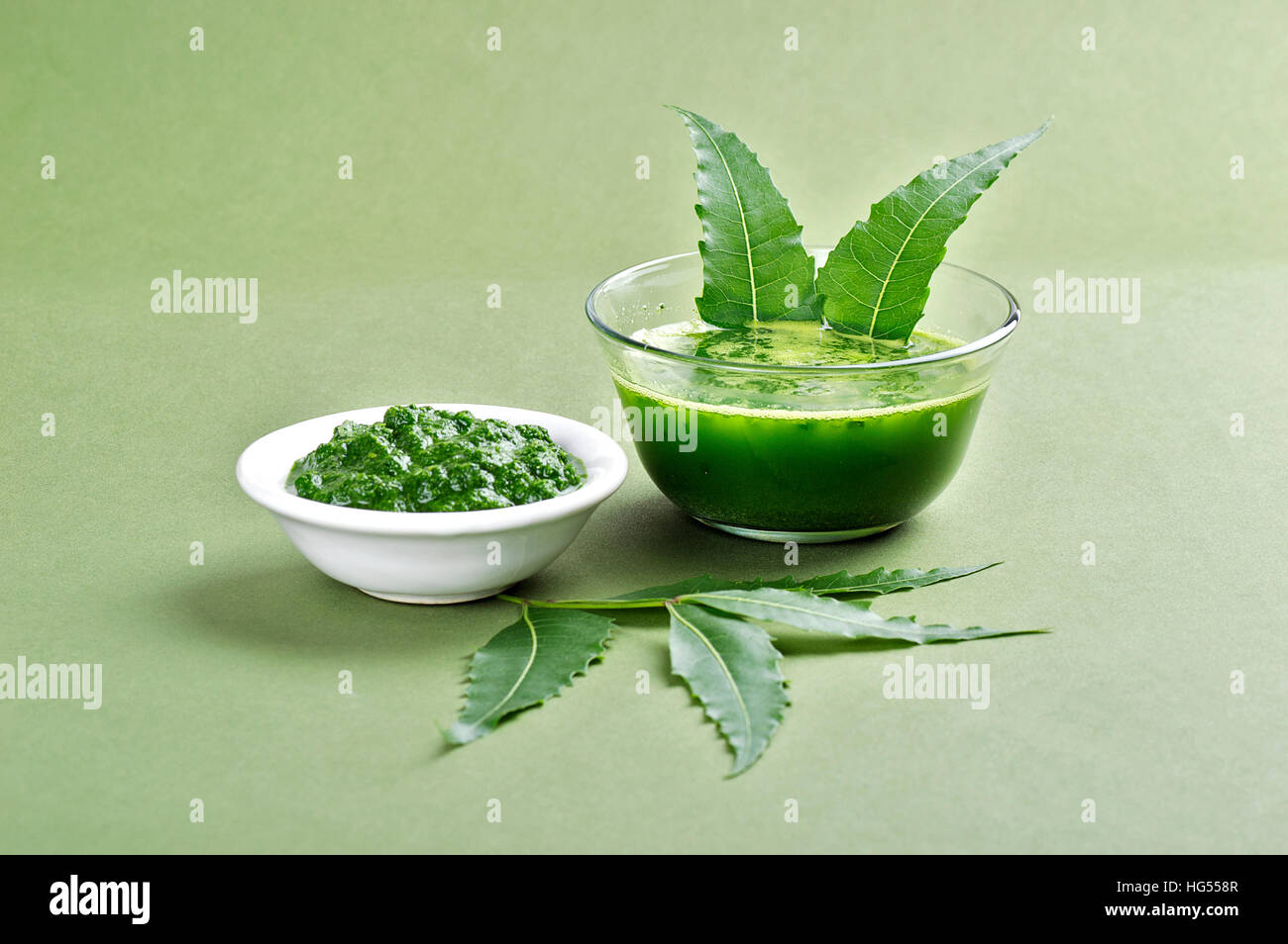 Medicinal Neem leaves paste and juice with leaves on green background ...