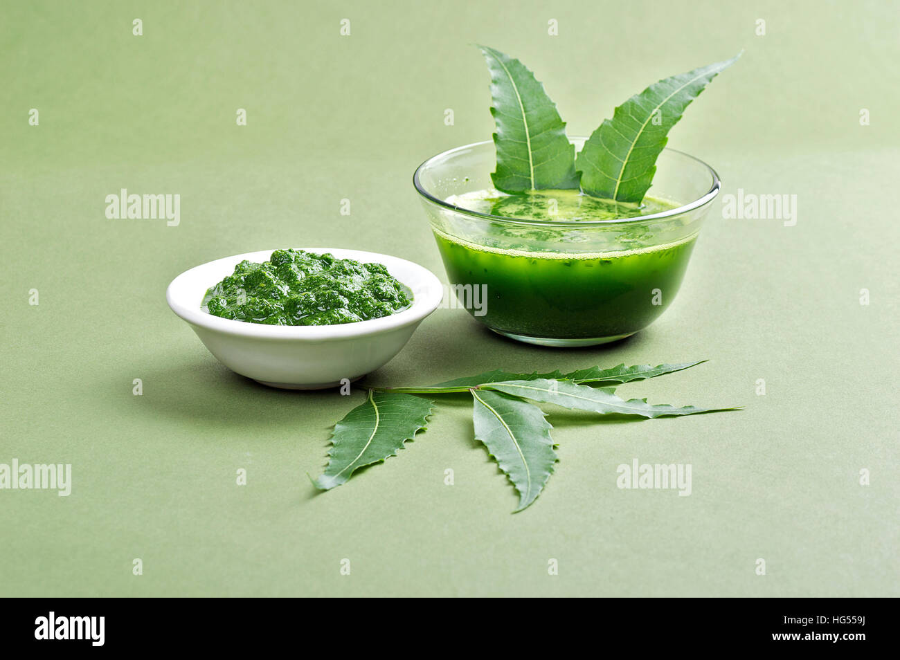 Medicinal Neem leaves paste and juice with leaves on green background ...