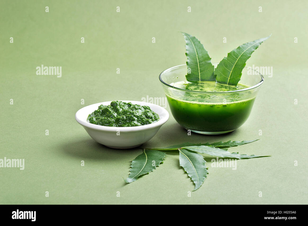 Medicinal Neem leaves paste and juice with leaves on green background ...