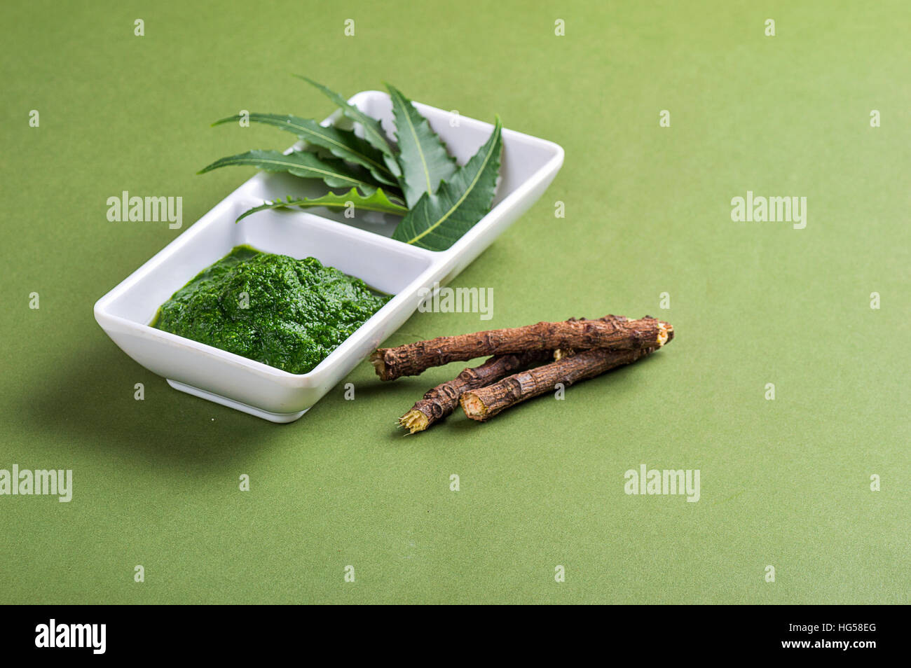 Medicinal Neem leaves paste and leaves with twigs on green background ...