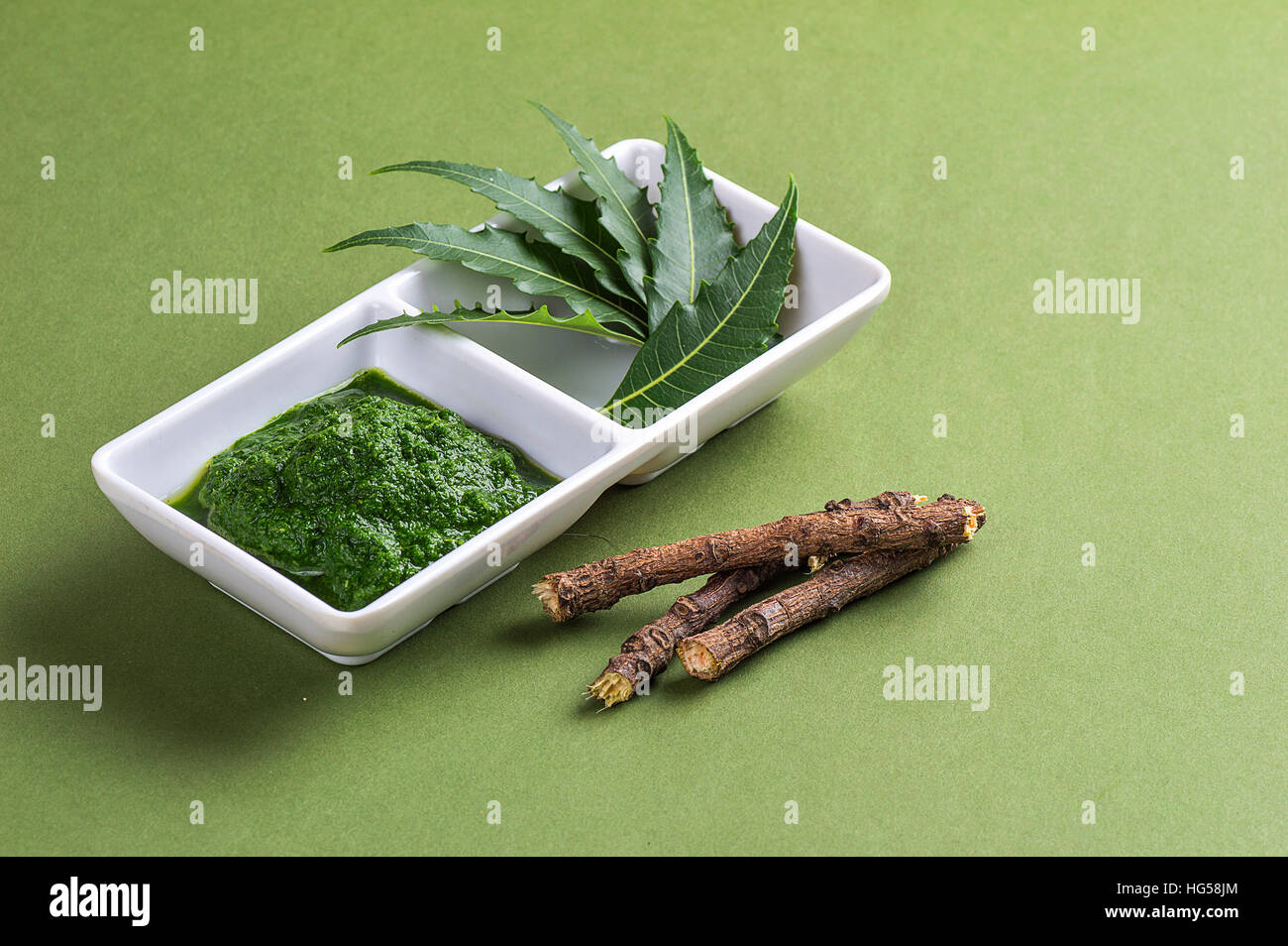 Medicinal Neem leaves paste and leaves with twigs on green background ...