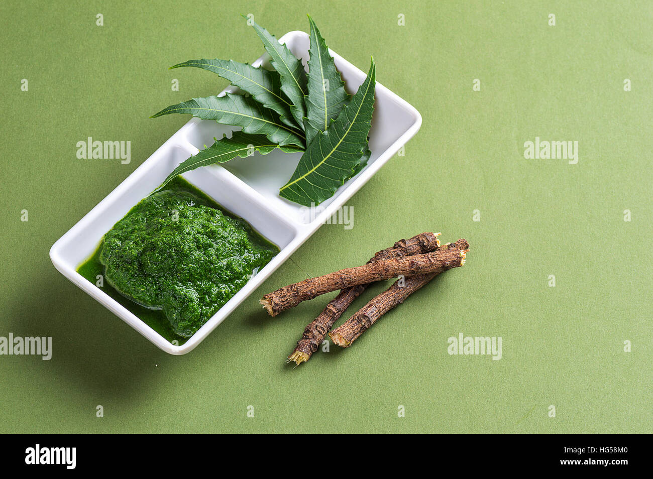 Medicinal Neem leaves paste and leaves with twigs on green background ...
