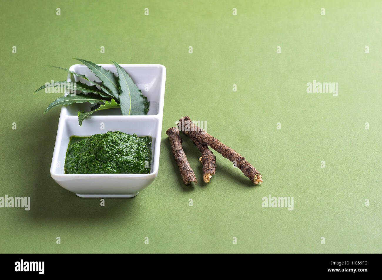 Medicinal Neem leaves paste and leaves with twigs on green background ...