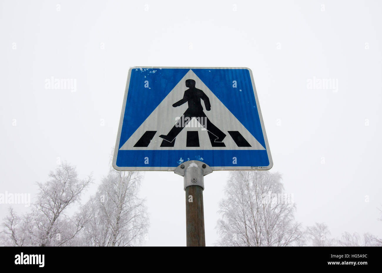 Pedestrian crossing road sign on winter sky background Stock Photo - Alamy