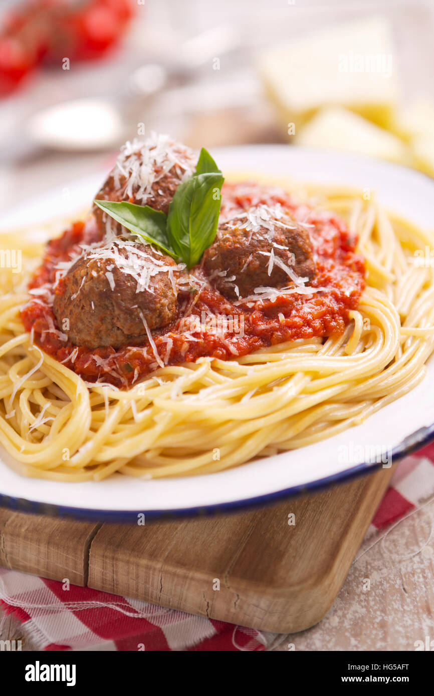 A plate with spaghetti with meatballs, topped with some grated parmesan ...