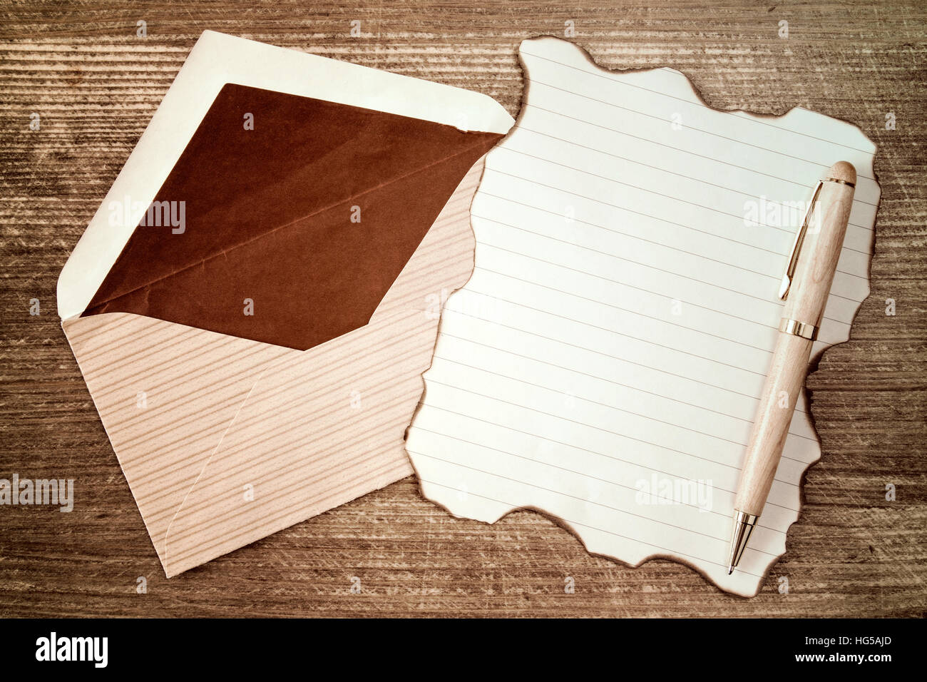 Open envelope with blank burned letter on wooden background Stock Photo ...