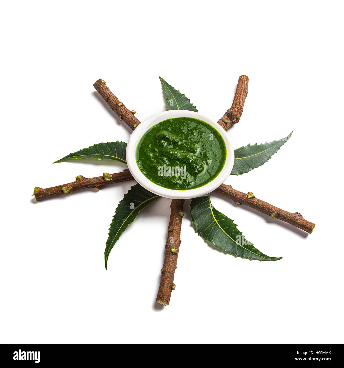 Medicinal Neem leaves with paste in bowl and twigs on white background ...