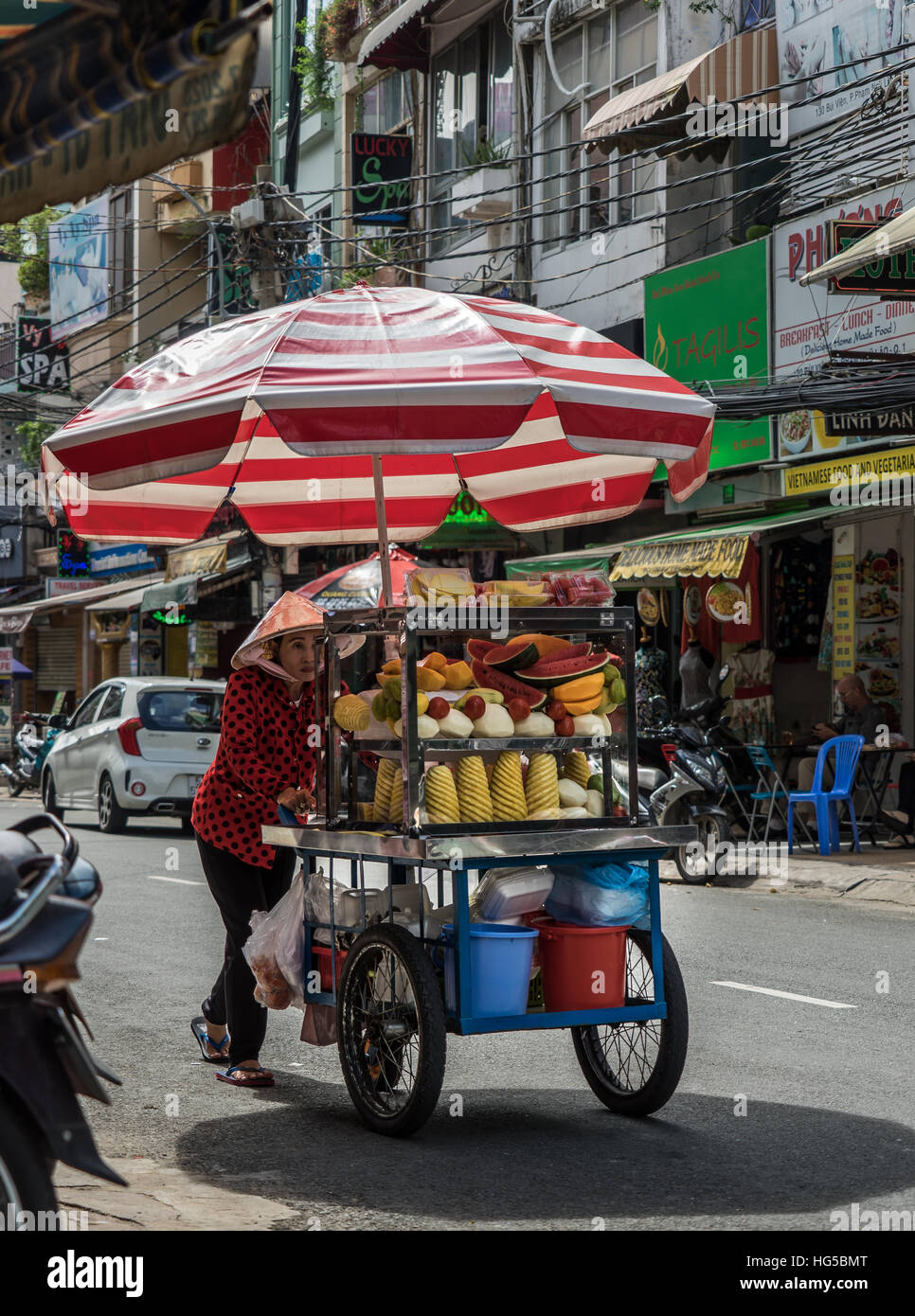 Vietnamese woman selling fresh fruit on a hand cart in Saigon, Ho Chi ...