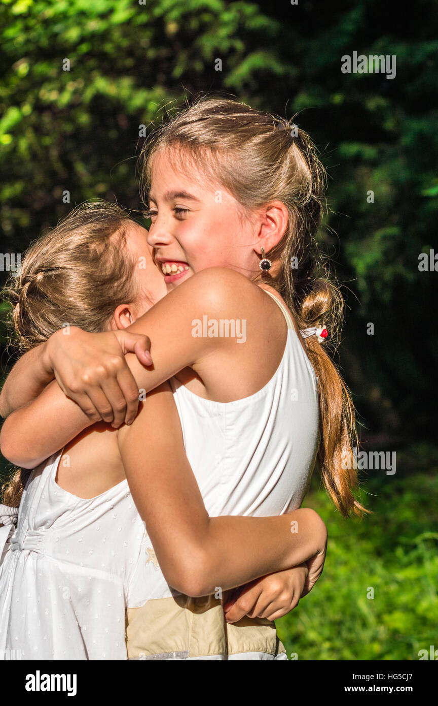 two daughters hugging in the park Stock Photo - Alamy