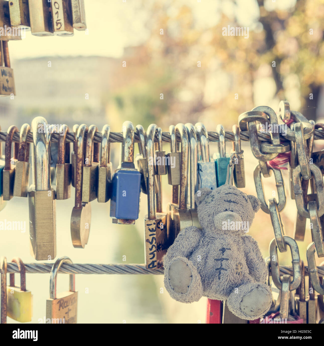 Teddy bear with love locks on a metal bridge Stock Photo - Alamy