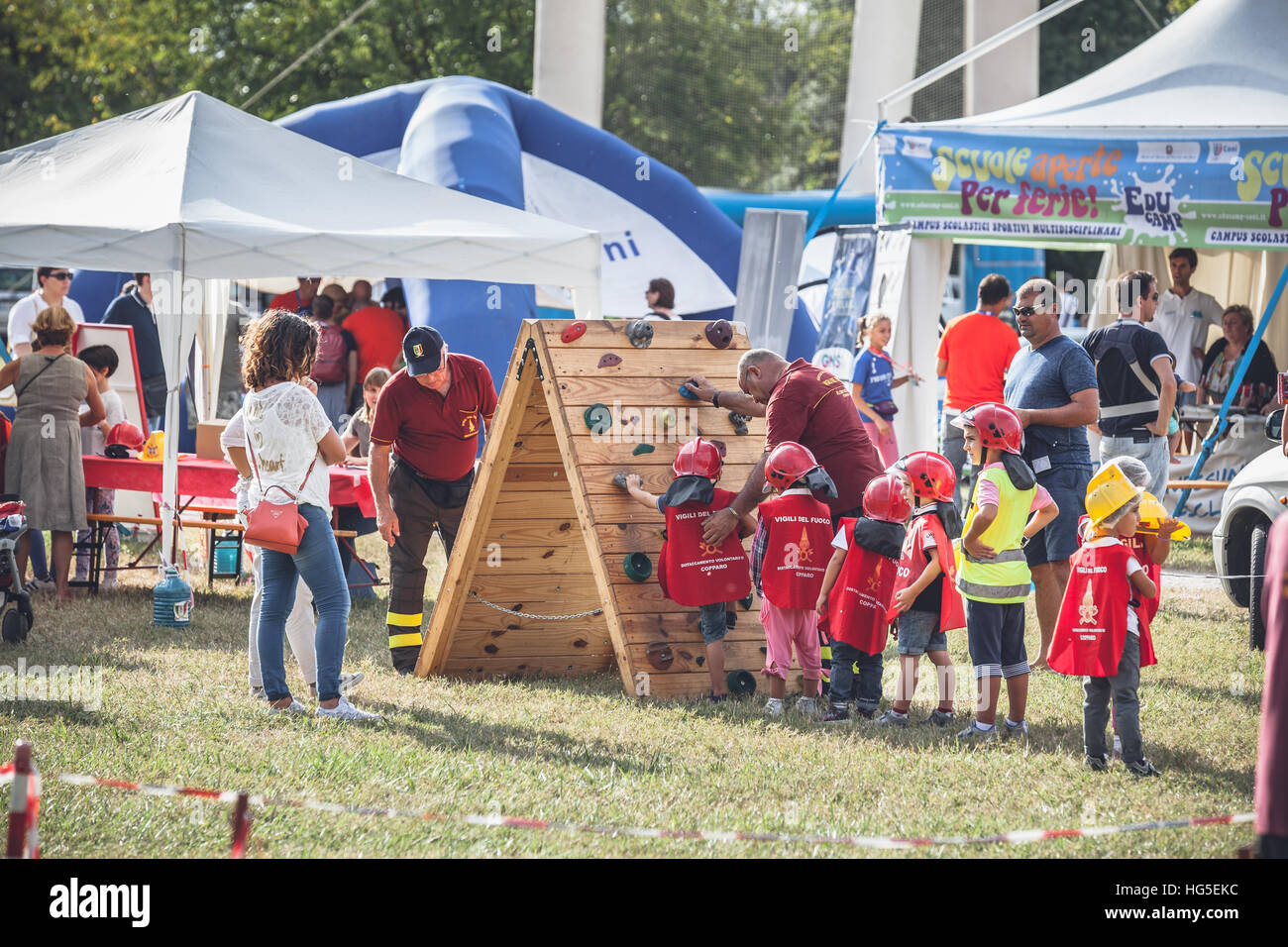 Italian Fireman teaching a group of young children how to climb on a ...