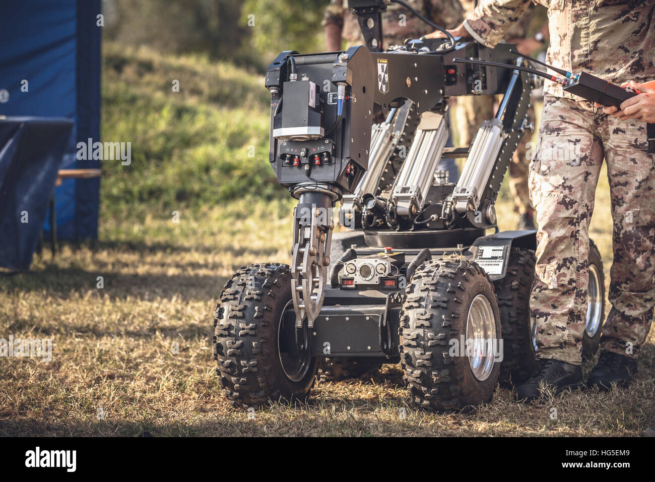 Italian soldier holding a remote from military car machine with robotic ...