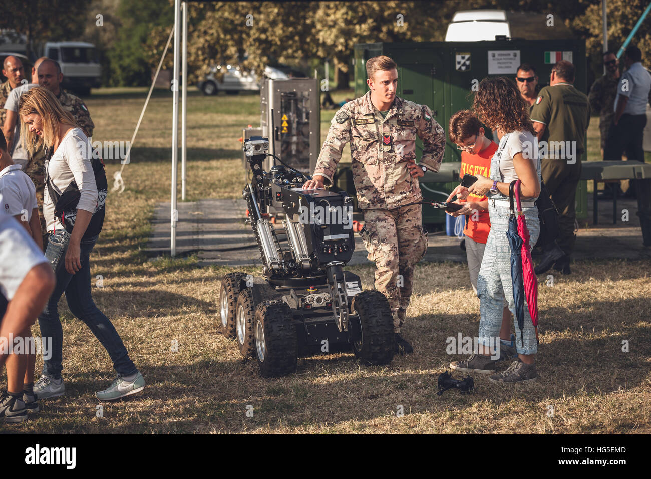 Italian soldier present a remote military car machine with robotic arm ...