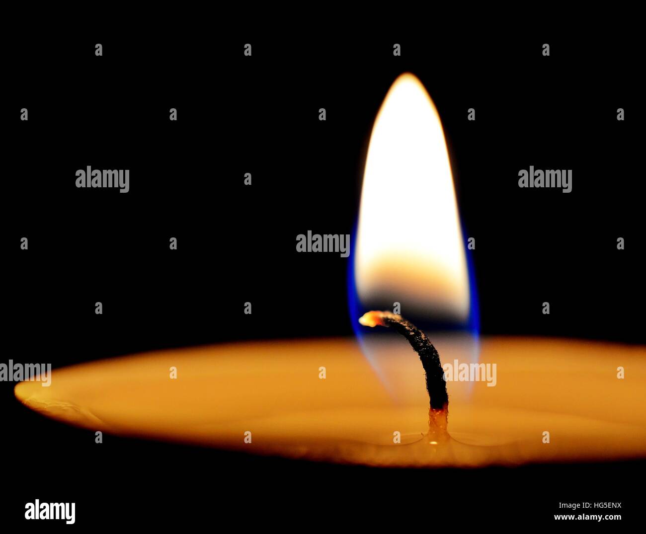 Burning wax candle at night closeup Stock Photo - Alamy