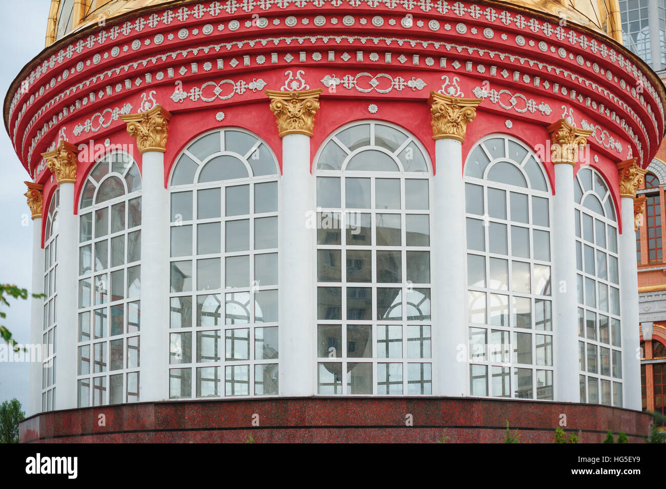 Red round building with large Windows and columns Stock Photo - Alamy