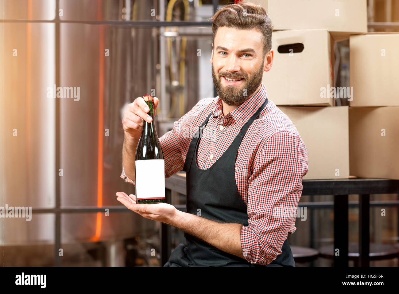 Brewer with bottle at the manufacturing Stock Photo - Alamy