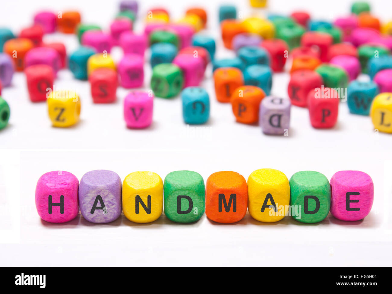 The word "handmade" on wooden multi-colored cubes on a background of ...