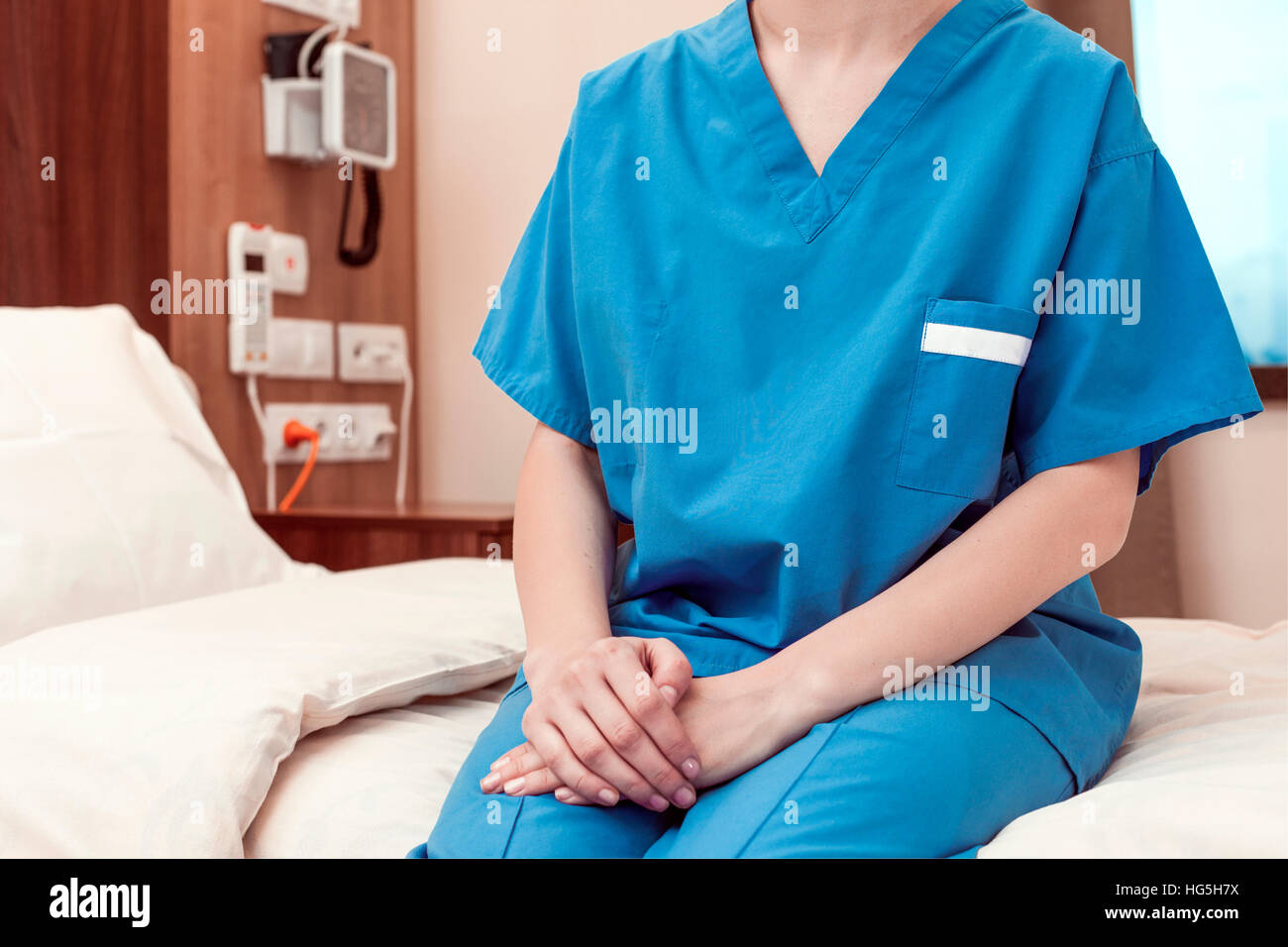 A patient sitting on a hospital bed with hands resting in his lap Stock ...