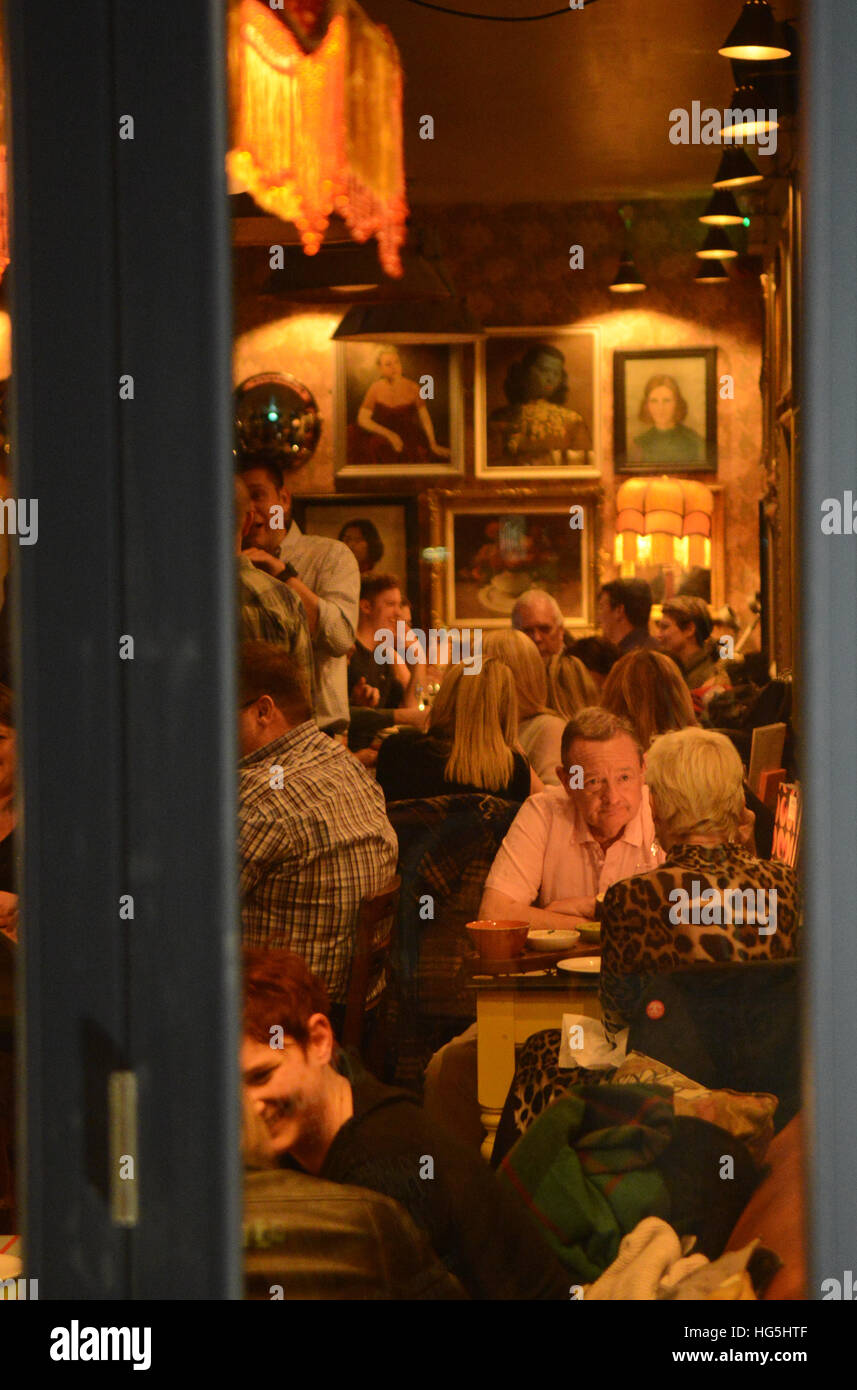 People enjoying a night out at a restaurant, relaxing with food and ...