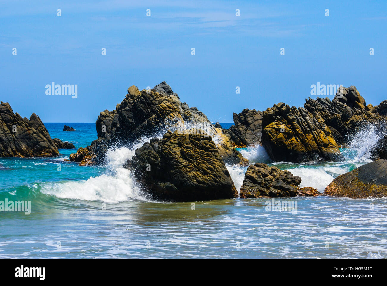 Waves crash against the rock formation in a beach Stock Photo - Alamy