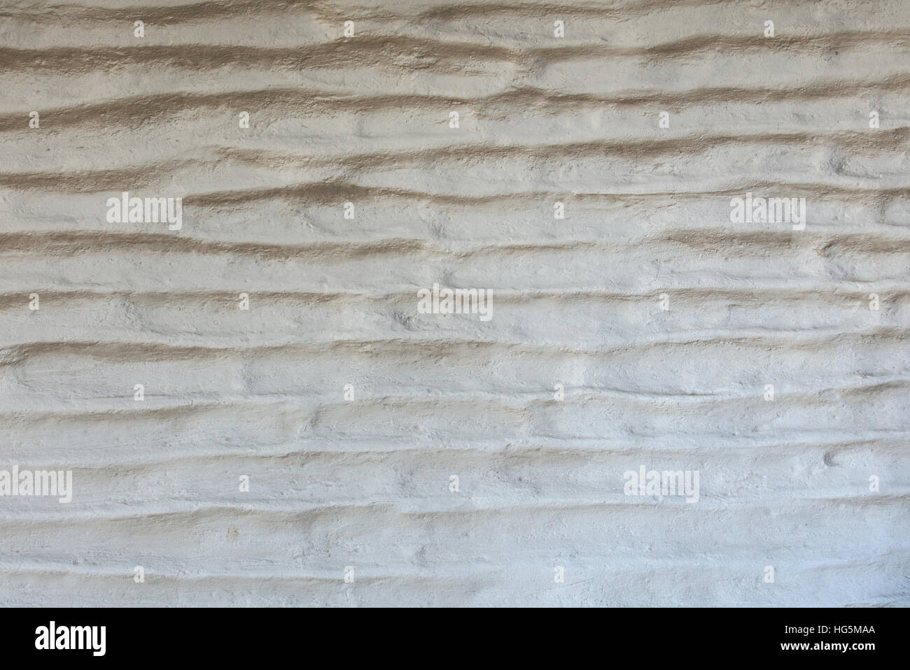 White and worn wall texture made of adobe bricks laid horizontally ...