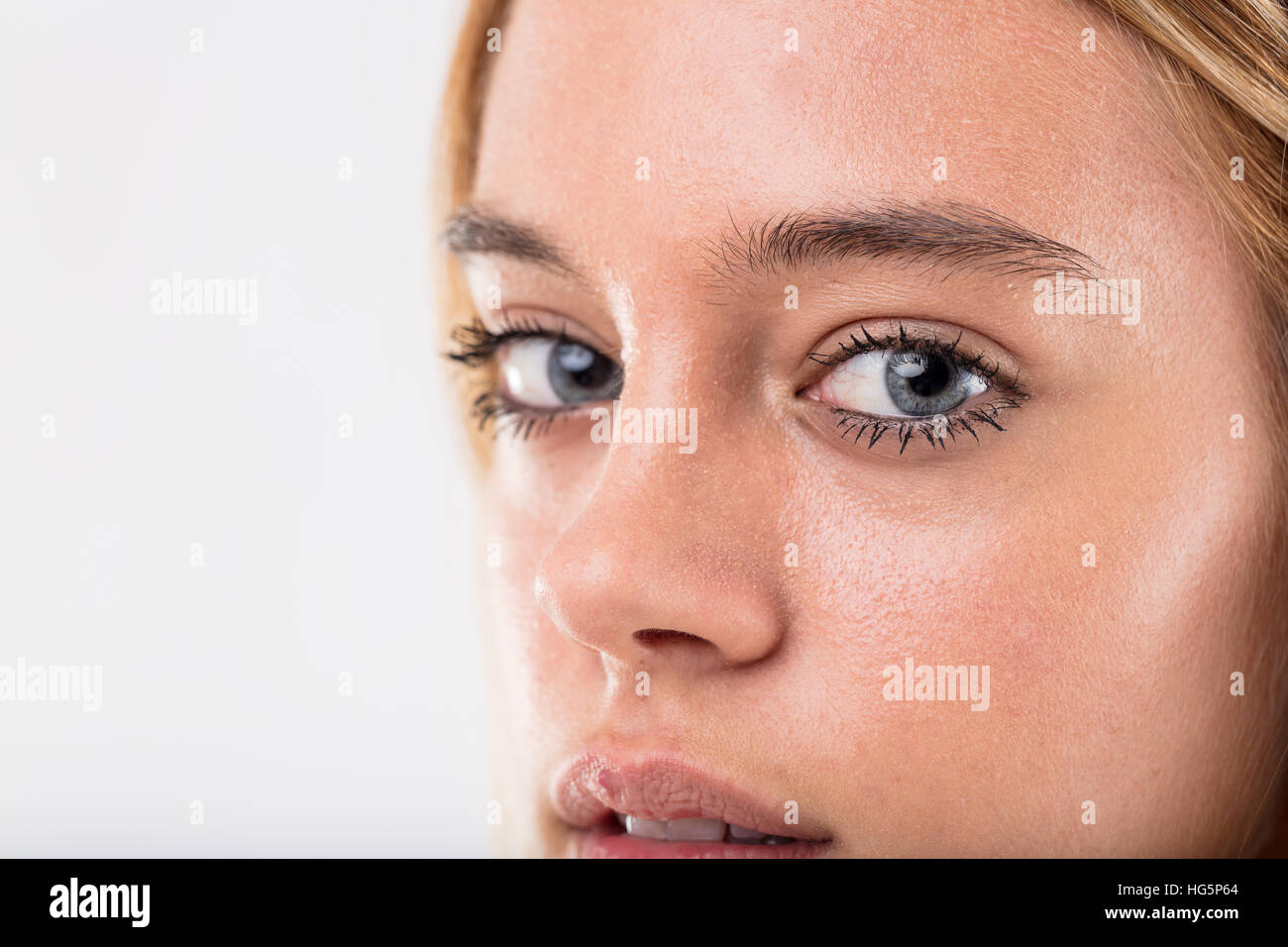 focus on the left eye on a close-up portrait of a beautiful blonde girl ...
