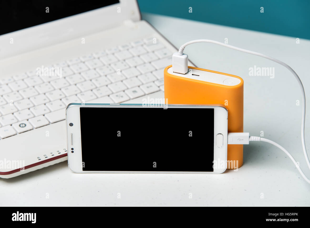 charging smart phone with portable external battery on Modern laptop in ...