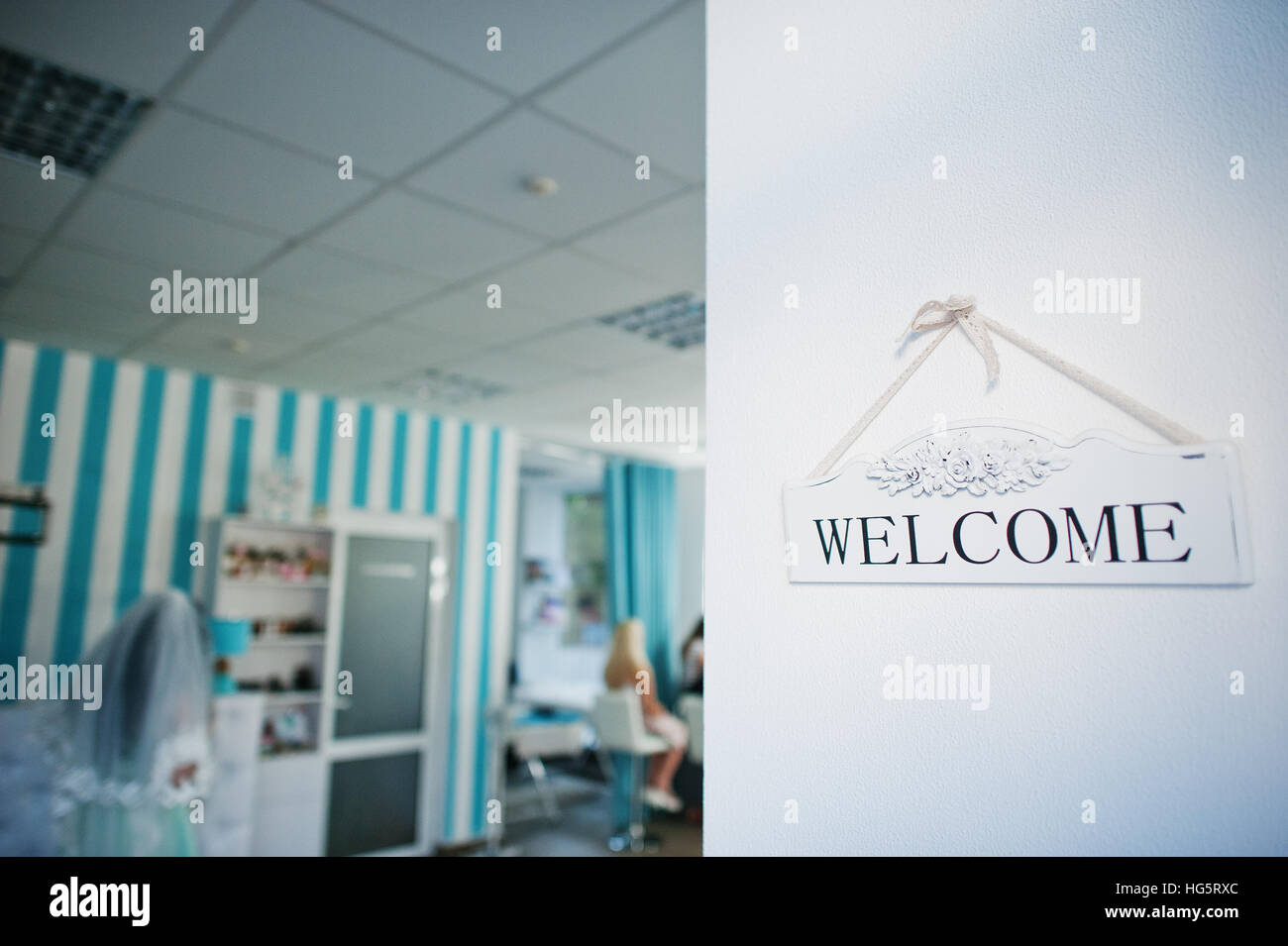 Wooden welcome sign blue beauty salon background Stock Photo - Alamy