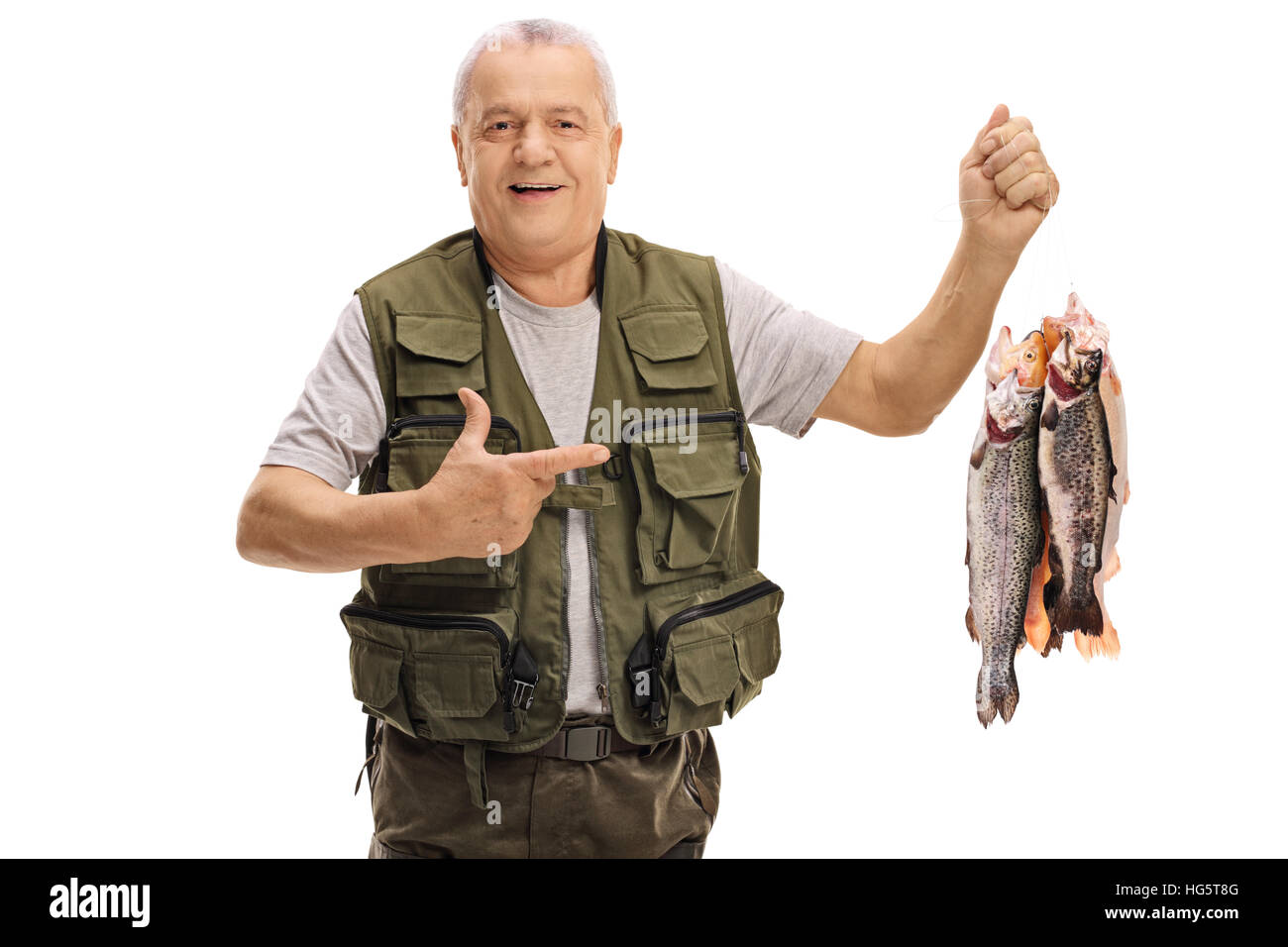 Joyful mature fisherman holding freshly caught fish and pointing ...