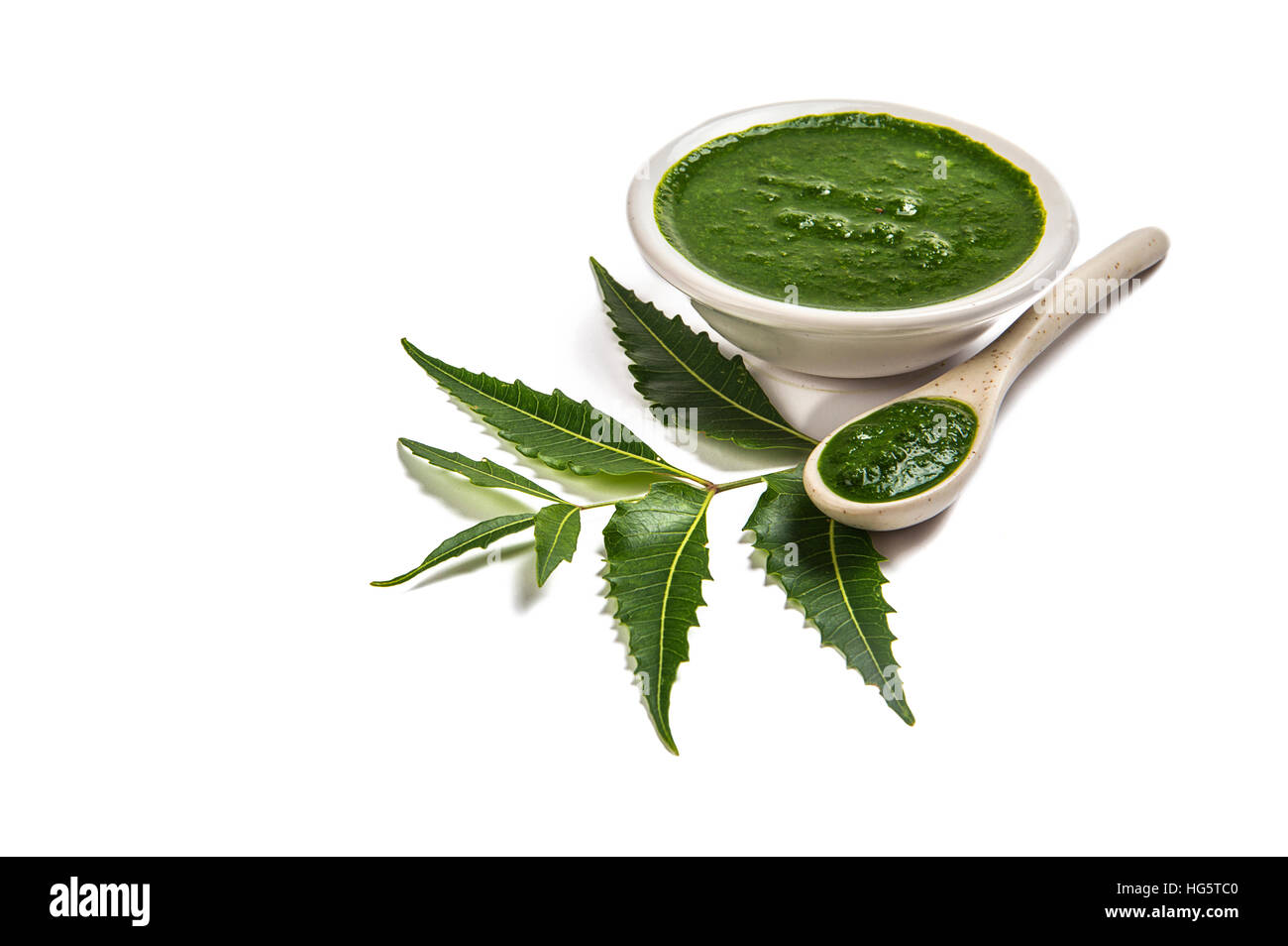 Medicinal Neem leaves with neem paste in spoon and plate on white ...