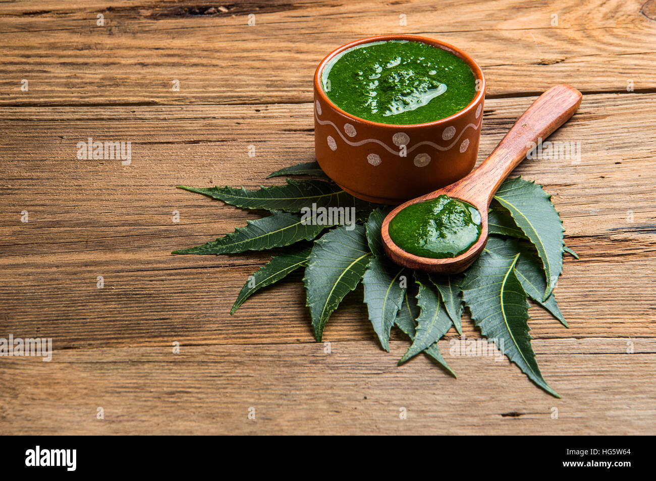 Medicinal Neem leaves with paste on wooden background Stock Photo - Alamy