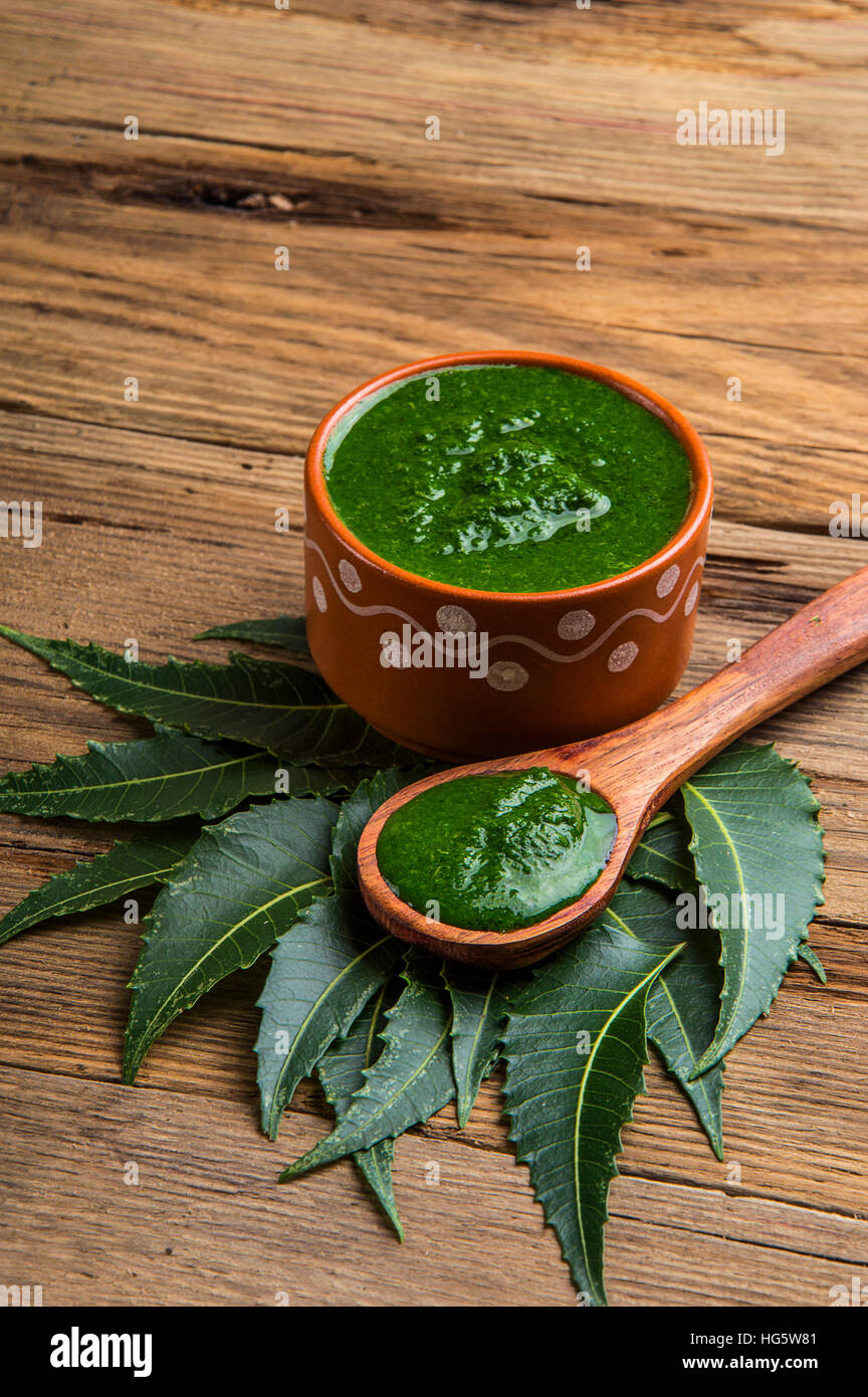 Medicinal Neem leaves with paste on wooden background Stock Photo - Alamy