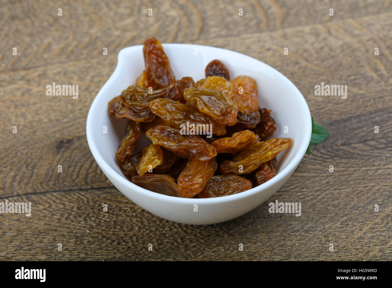 Sweet raisins in the bowl with mint leaves Stock Photo - Alamy