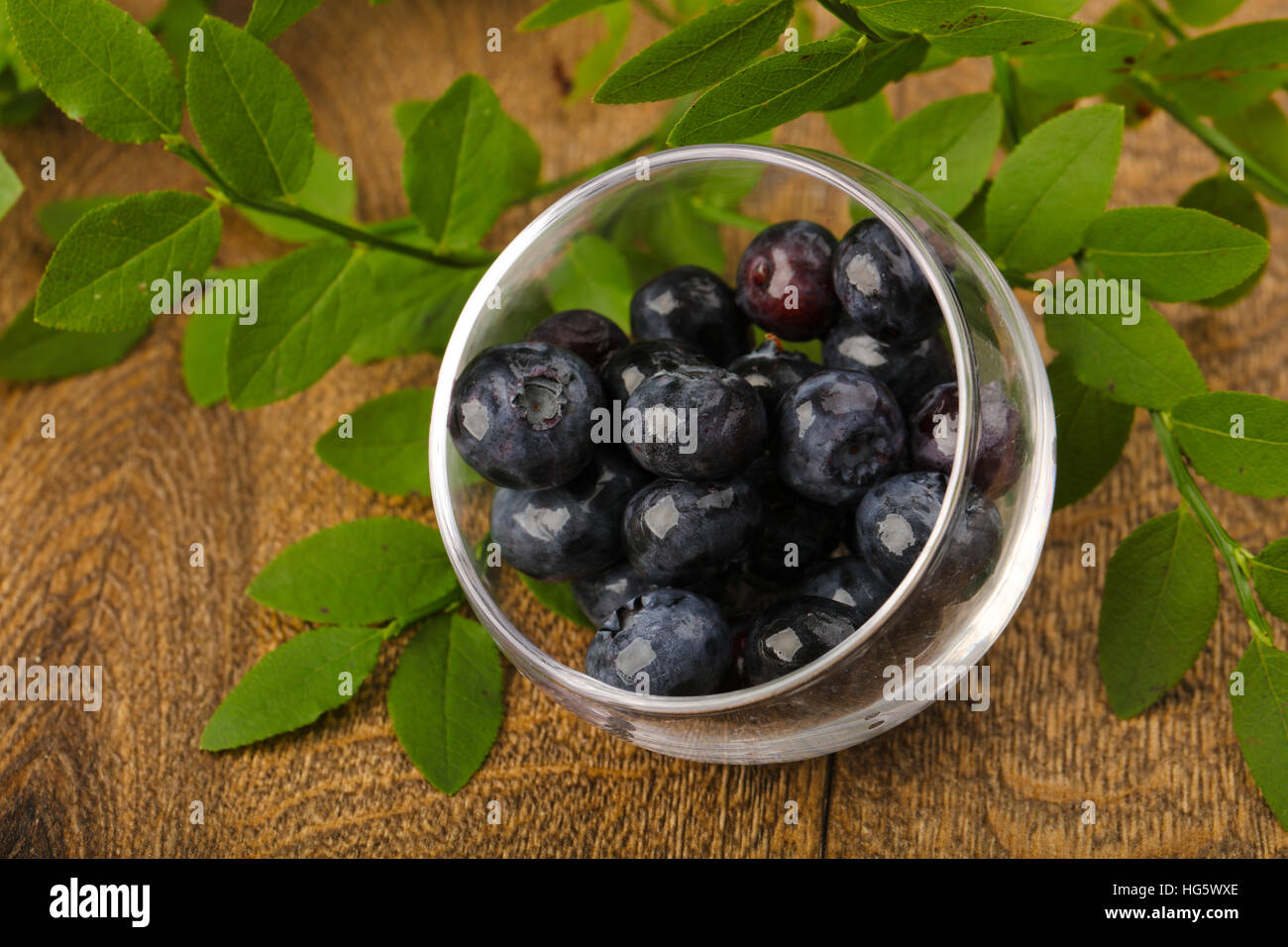 Ripe Blueberry heap with leaves on wood background Stock Photo - Alamy