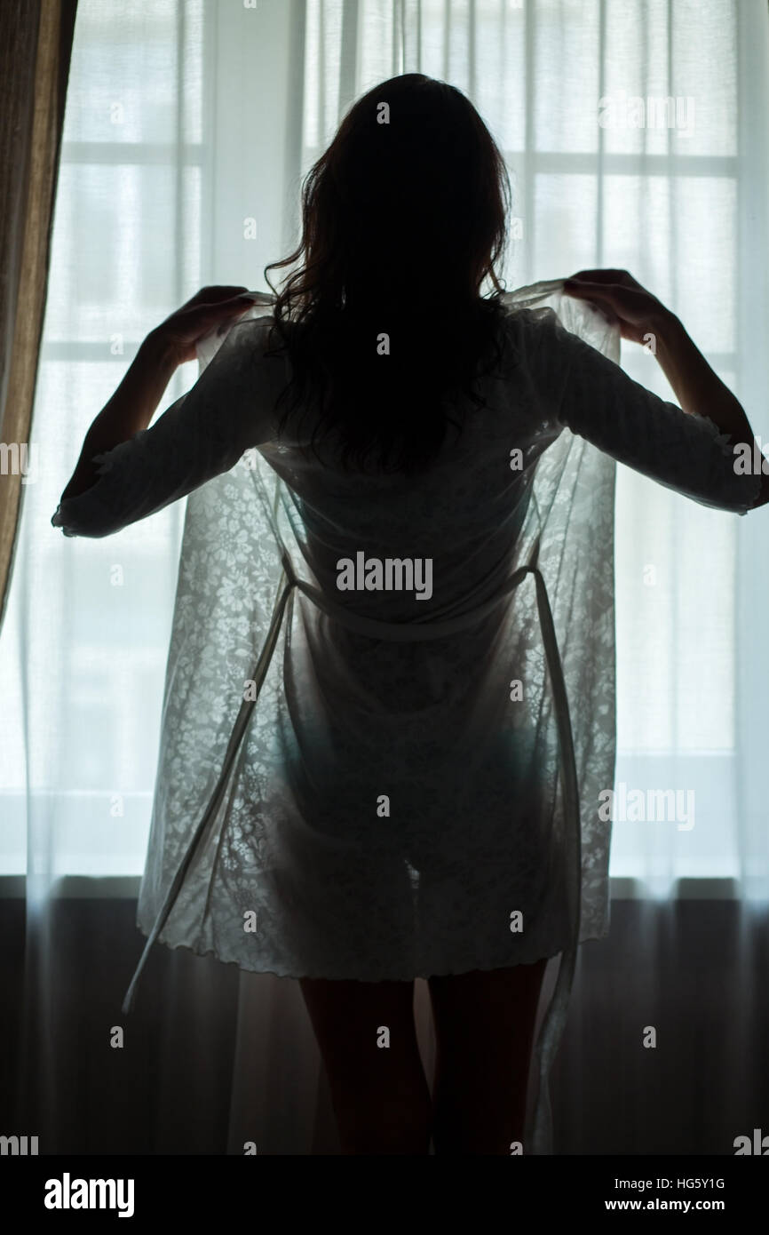 Lady standing near window Stock Photo - Alamy