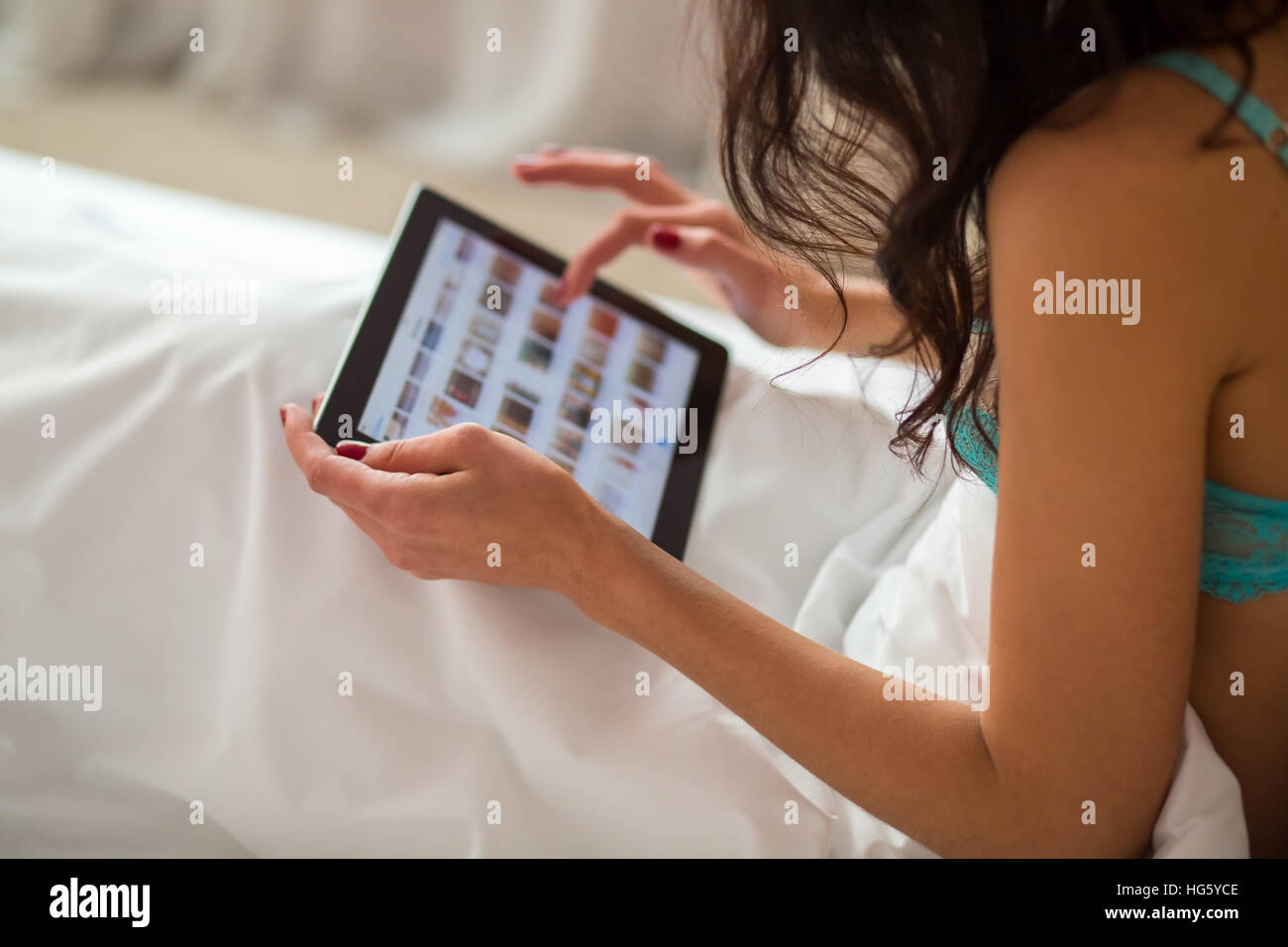 Female in bed with tablet Stock Photo - Alamy