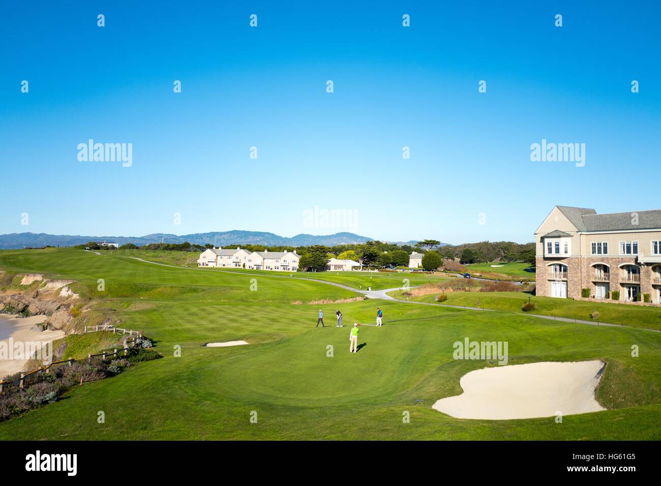 Golfers play on the Half Moon Bay Golf Links, with a portion of the ...