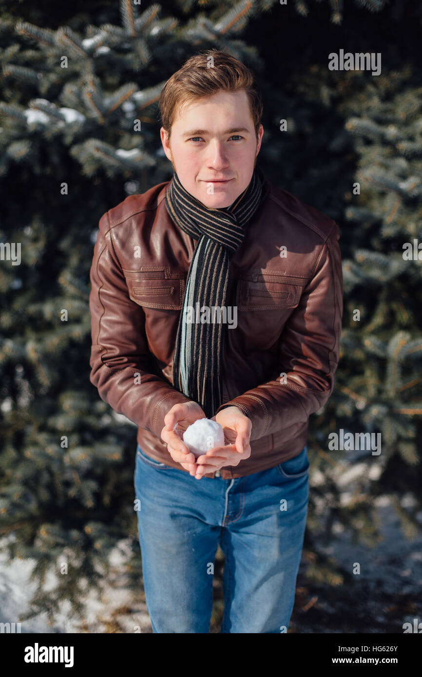 Man playing snowballs in sunny winter day Stock Photo - Alamy