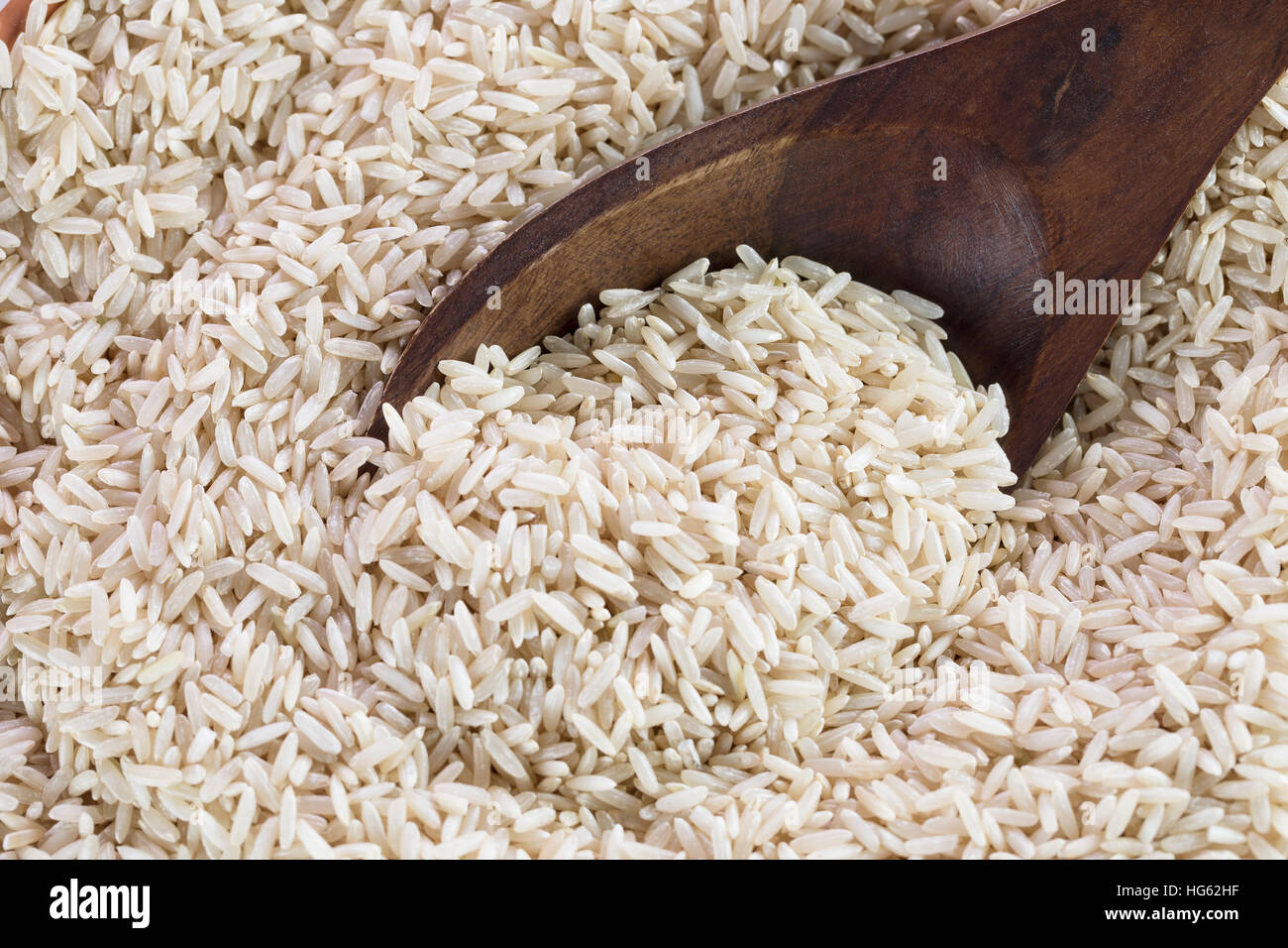 Wooden spoon scooping brown rice Stock Photo - Alamy
