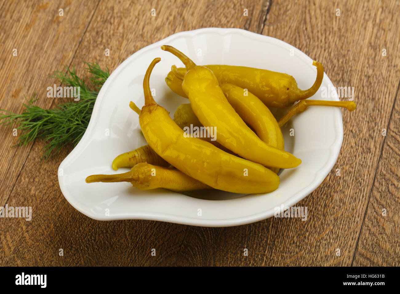 Pickled green pepperoni pepper in the bowl on wood background Stock ...