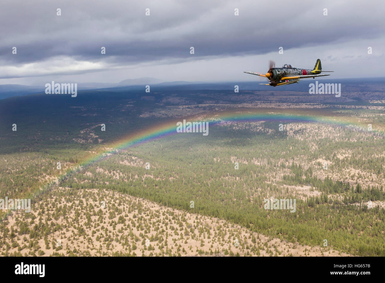 A Japanese A6M Zero and a Ki-43 Oscar fly in formation above a rainbow ...