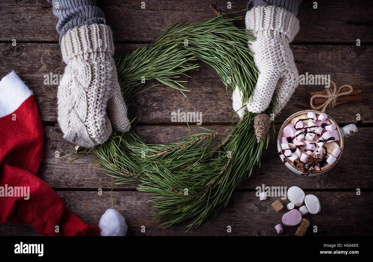 Woman in mittens making Christmas wreath. Selective focus, top view ...